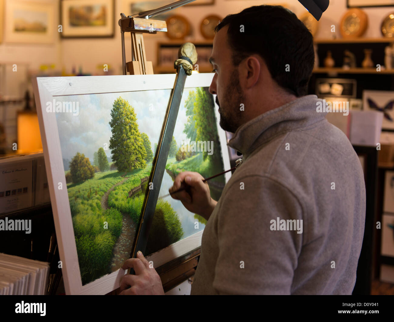 Cockington, Devon, England, UK. An artist at work on a painting in his ...