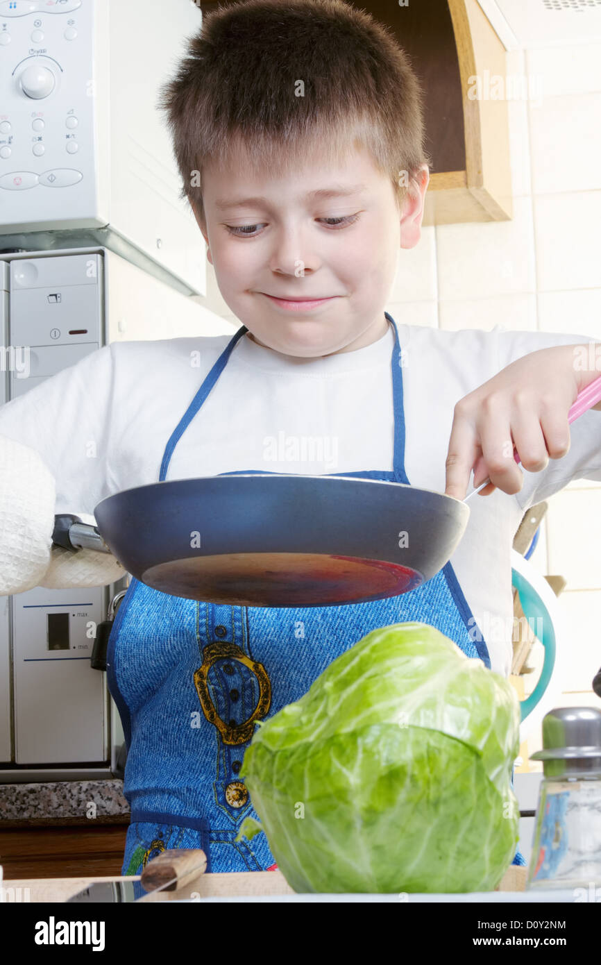 Smiling kid with frying-pan Stock Photo - Alamy