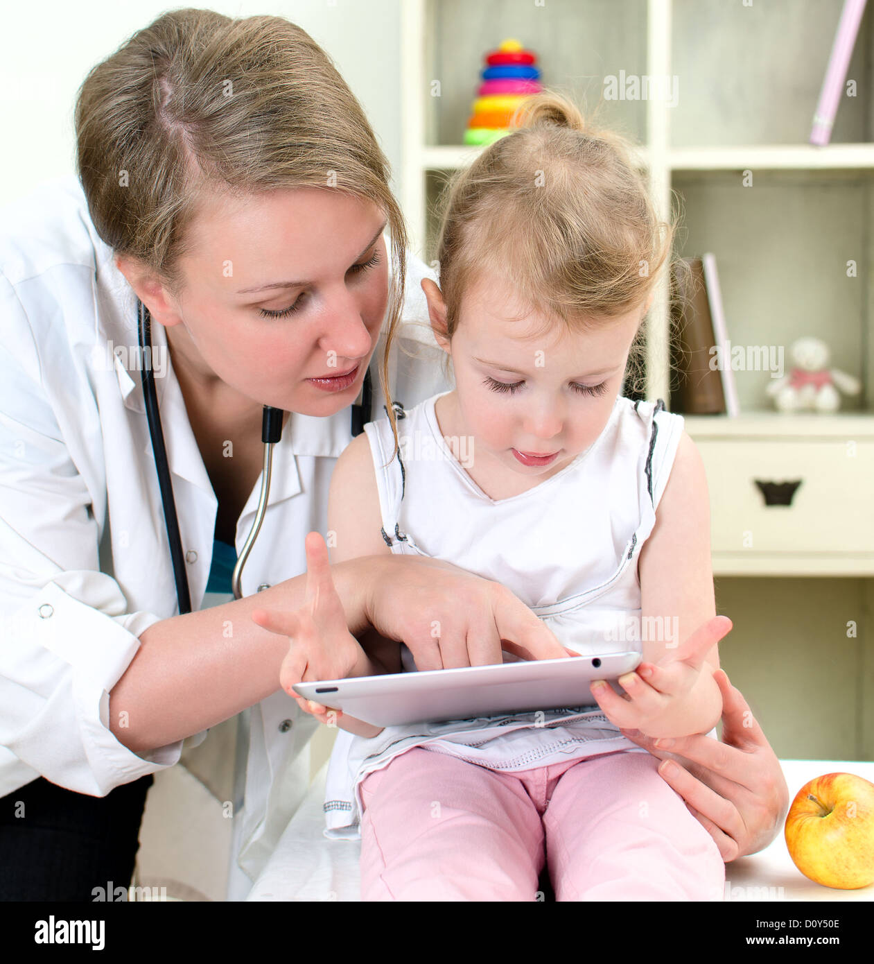 Pediatrician and little girl using tablet computer Stock Photo - Alamy