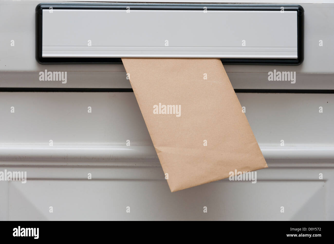 Brown envelope arriving through the letter box Stock Photo - Alamy