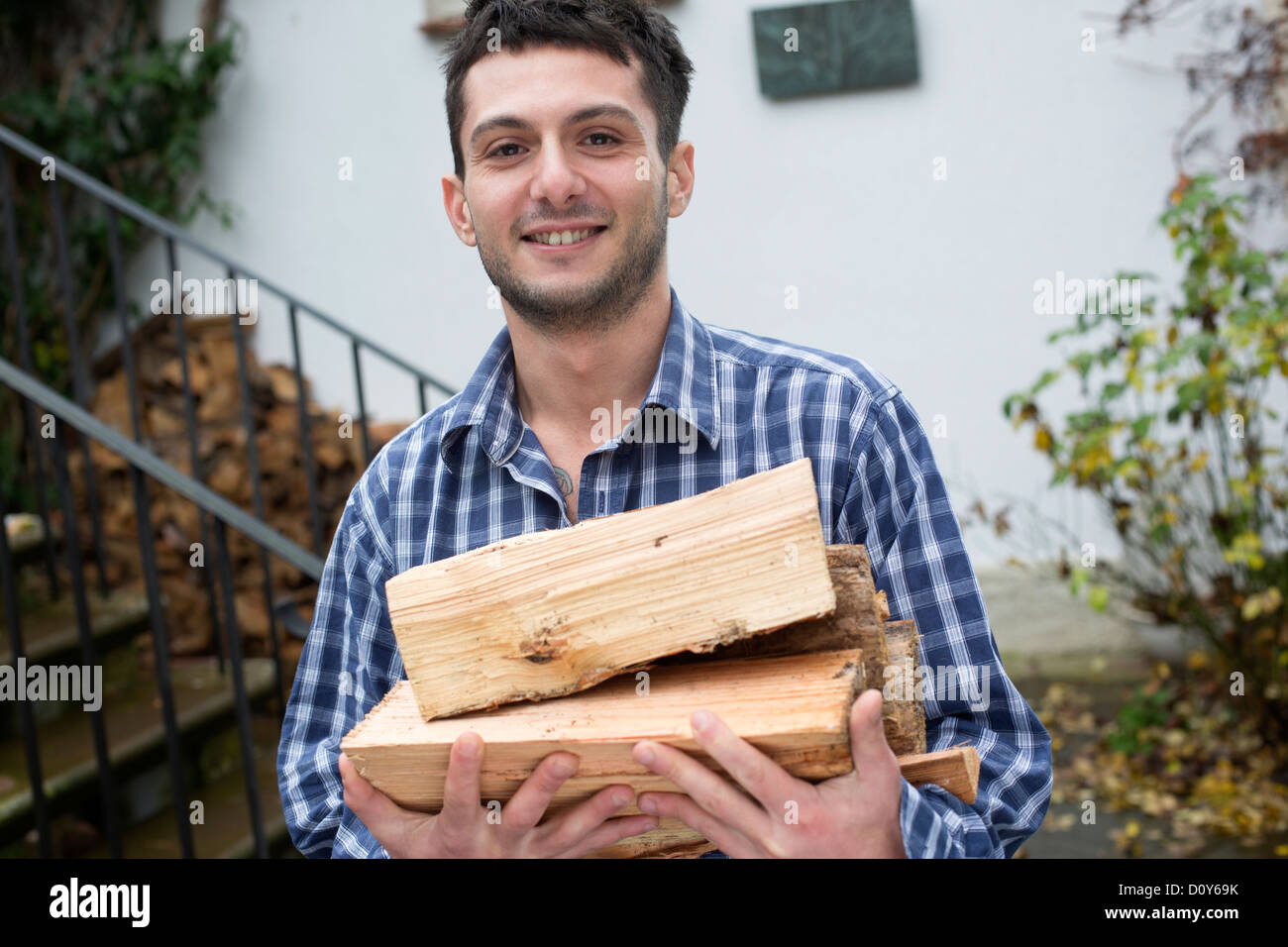 Young man carrying firewood hi-res stock photography and images - Alamy