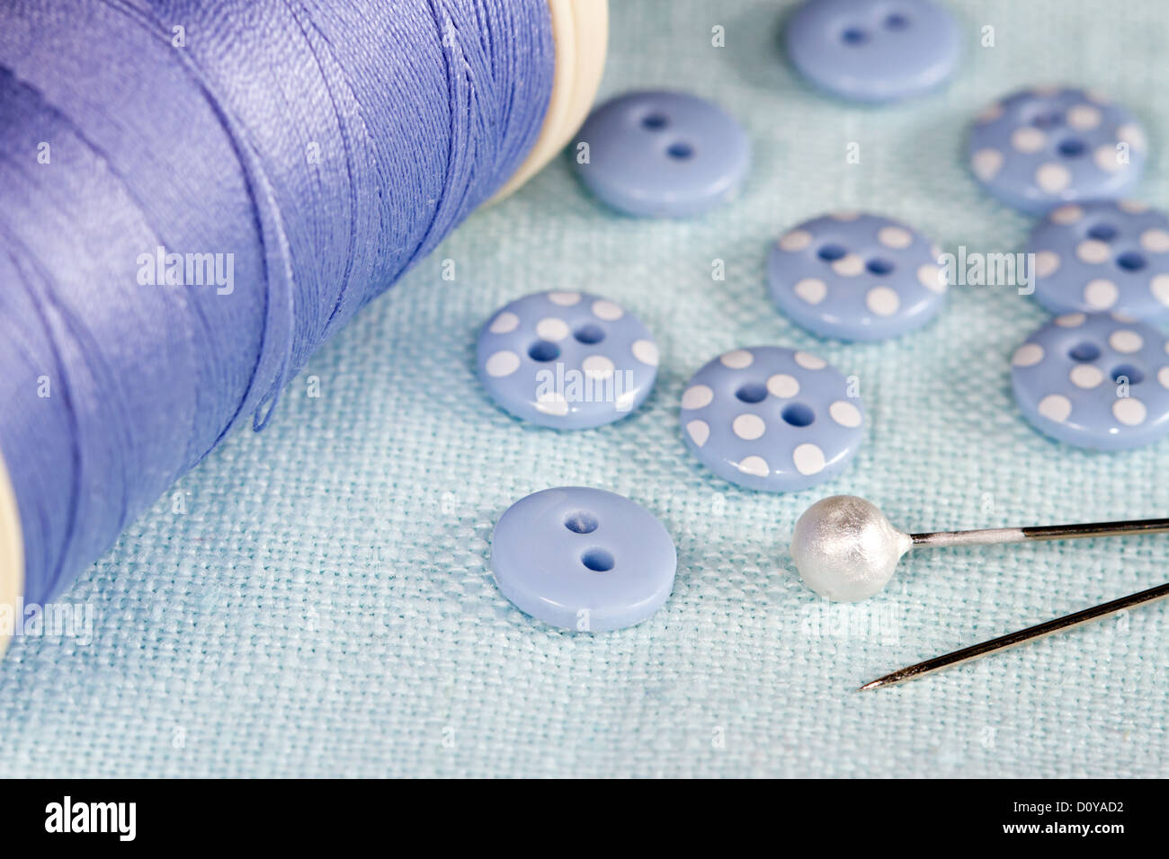 Buttons, thread and pins on fabric, sewing background Stock Photo - Alamy