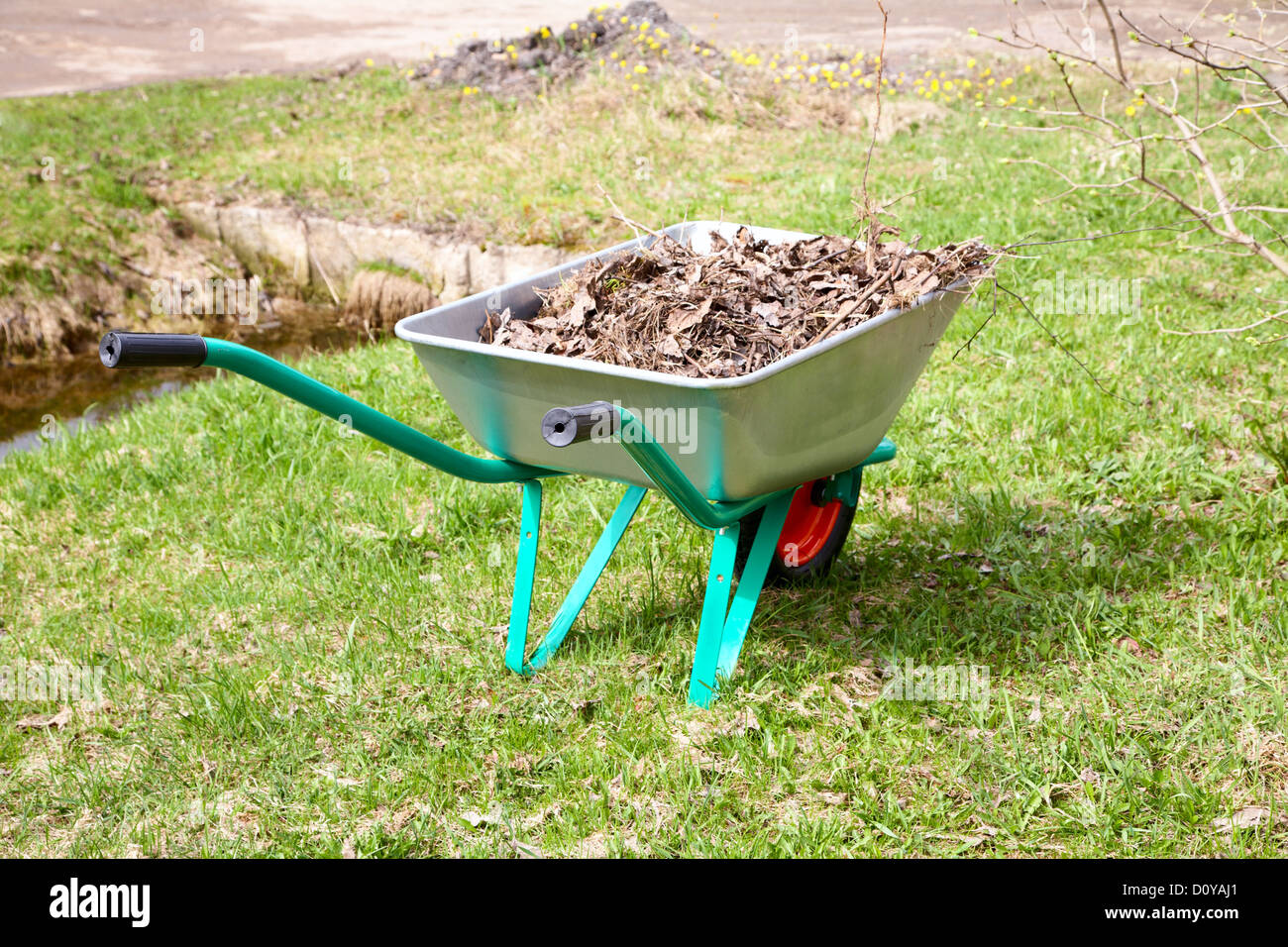 The garden cart with heap of dry leaves Stock Photo - Alamy