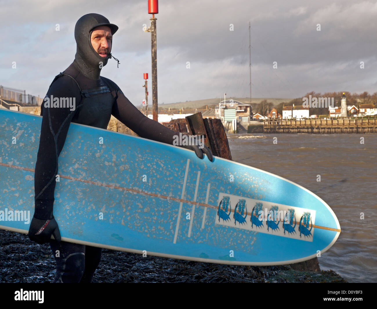 A man prepares to go surfing in Shoreham Harbour, in winter Stock Photo ...