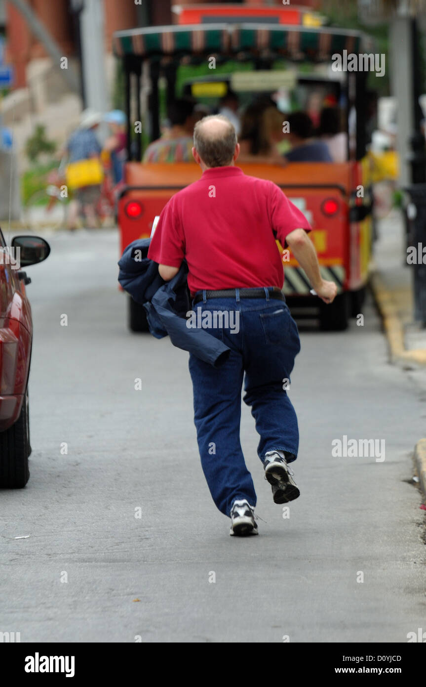 Tourist chasing a bus down Front Street in Key West Florida Stock Photo ...
