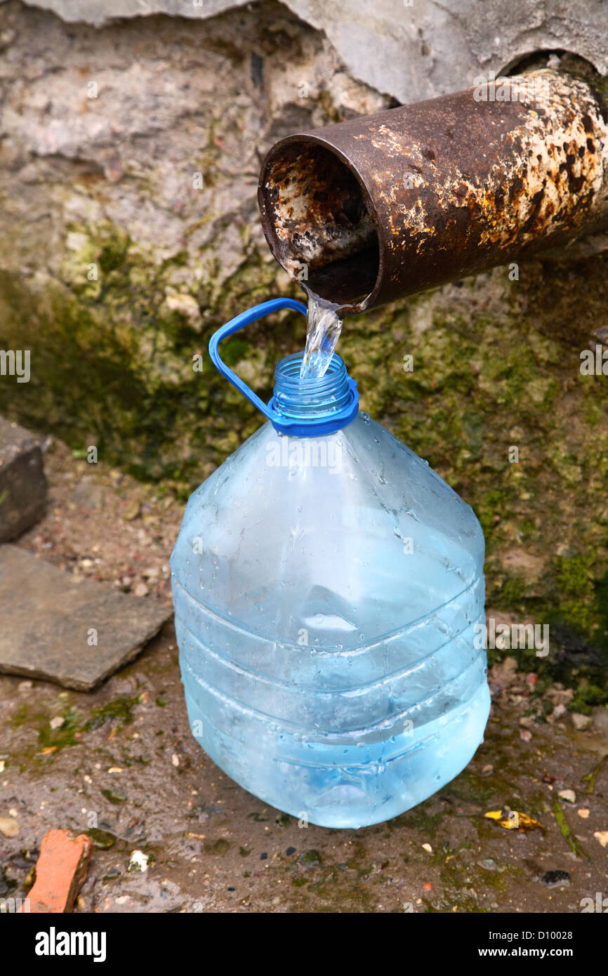 Filling bottle by spring water Stock Photo - Alamy