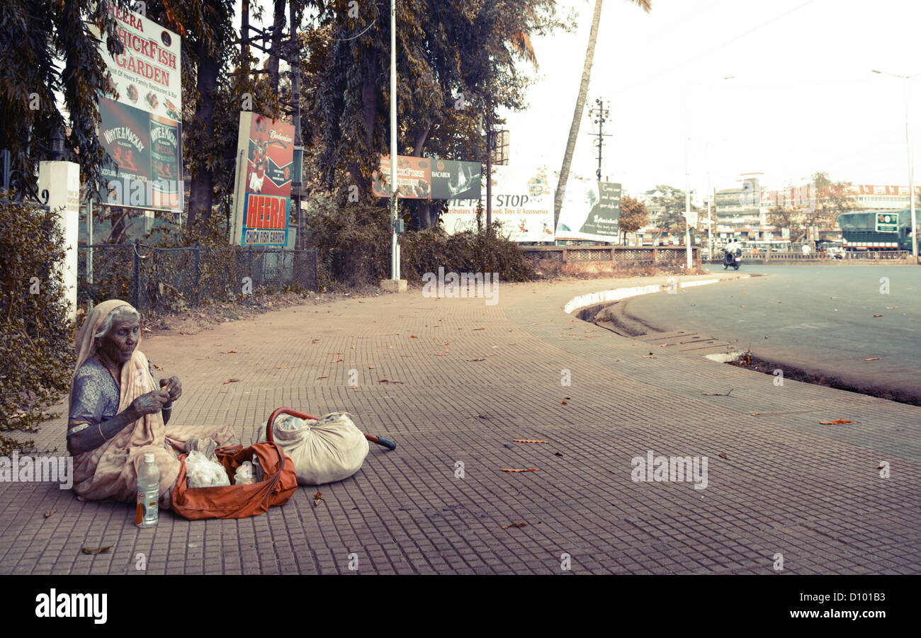Editorial photo of the beggar Indian woman sitting on the street. Goa ...