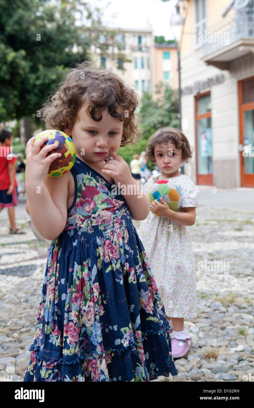 Little girls playing in the street with balls Stock Photo - Alamy