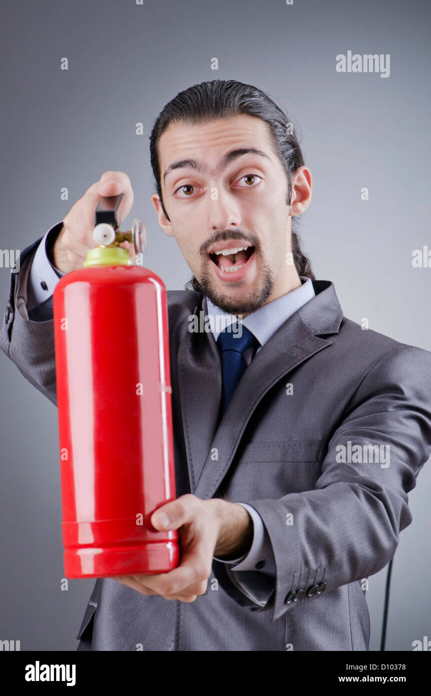 Man with fire extinguisher in firefighting concept Stock Photo - Alamy