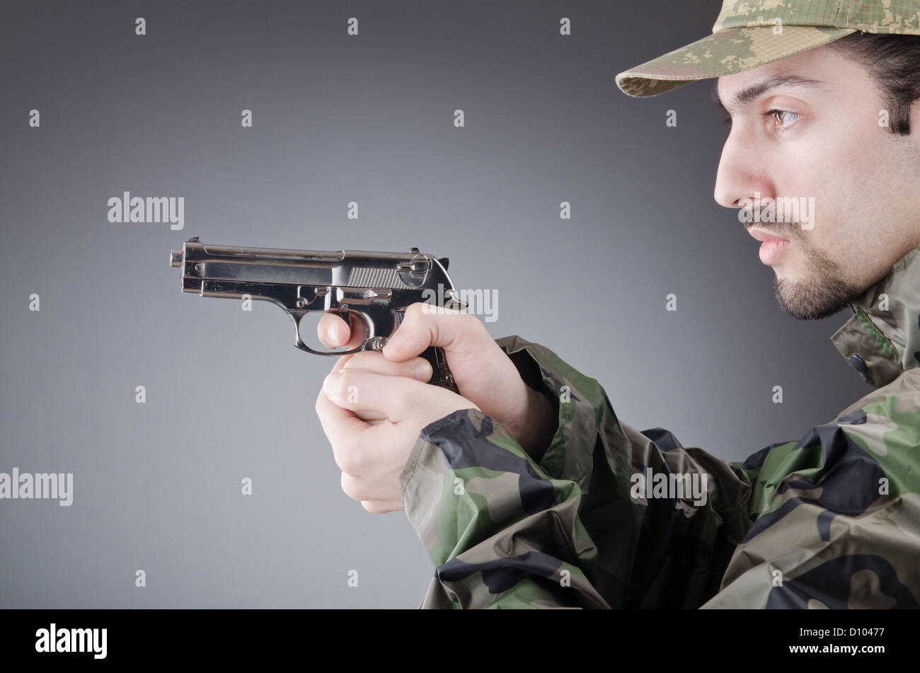 Soldier with gun in studio shooting Stock Photo - Alamy