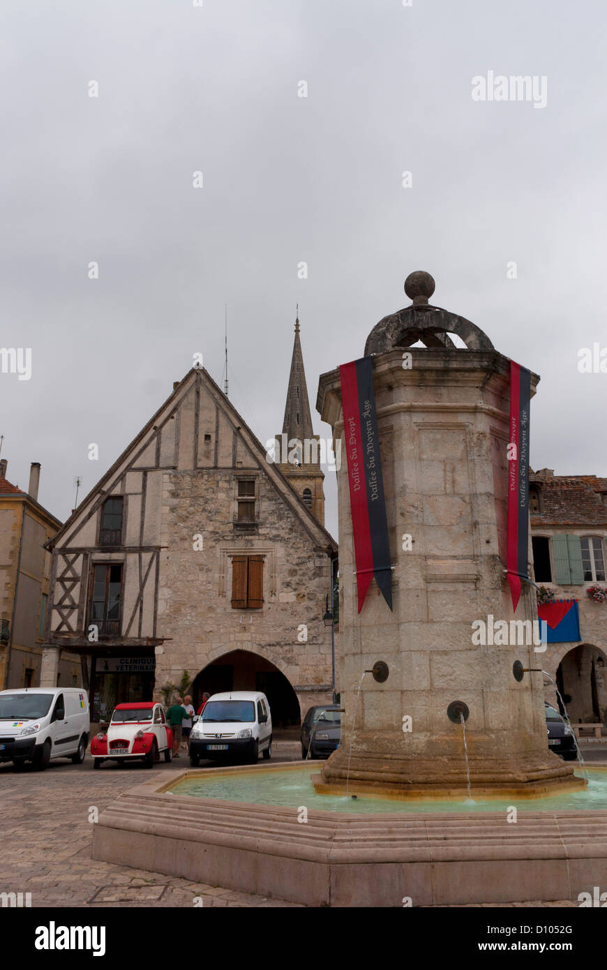 The fountain in the traditional main square in Eymet, in the Dordogne ...