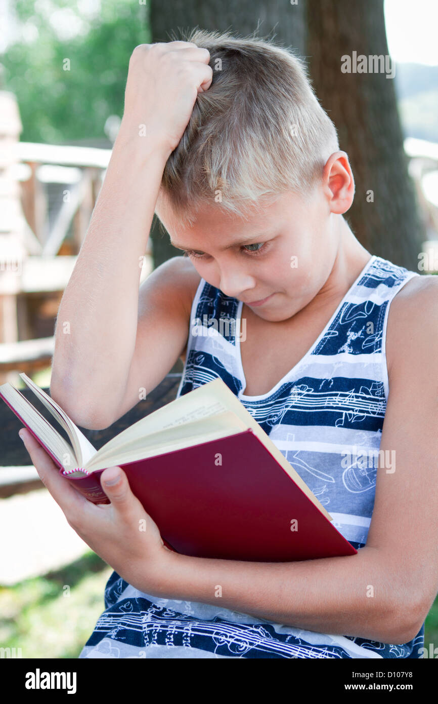 boy is reading a book and thinking on the nature Stock Photo - Alamy