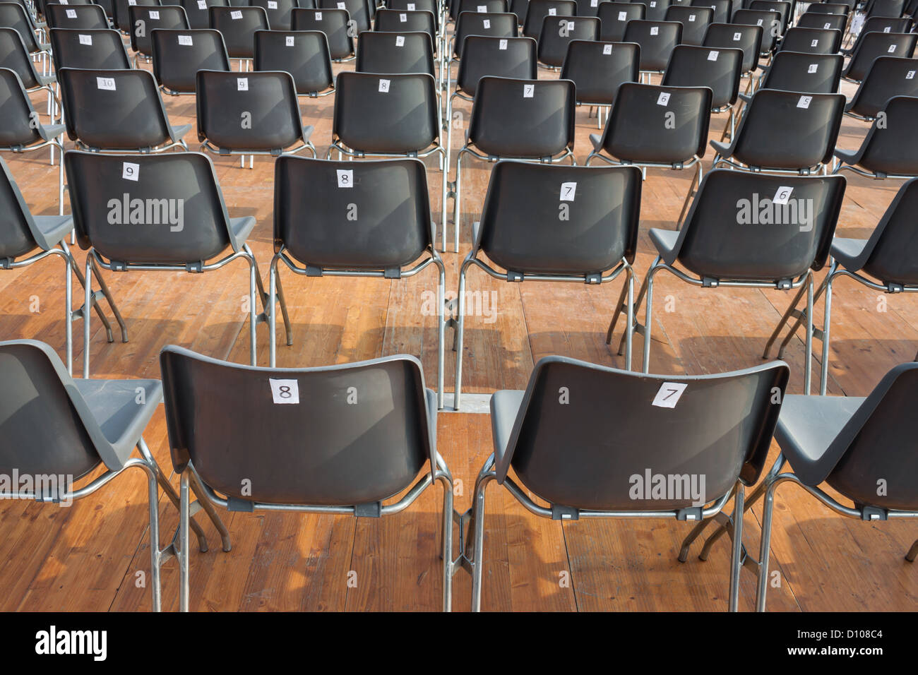 Empty numbered chairs lined up Stock Photo - Alamy