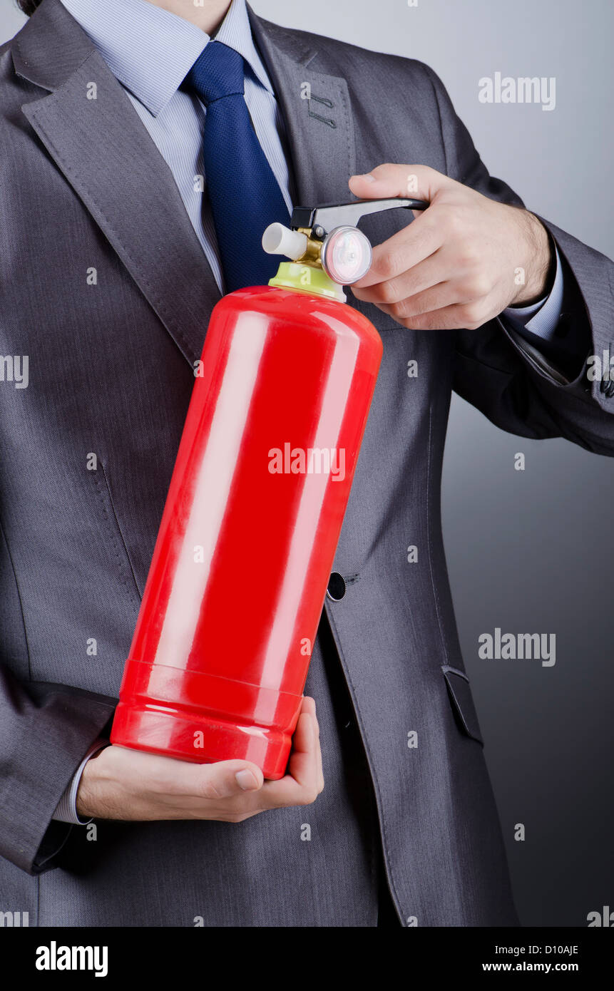 Man with fire extinguisher in firefighting concept Stock Photo - Alamy