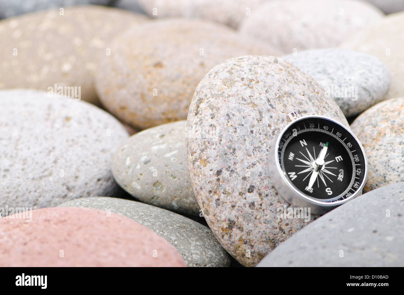 Navigation compass on stone pebbles Stock Photo - Alamy