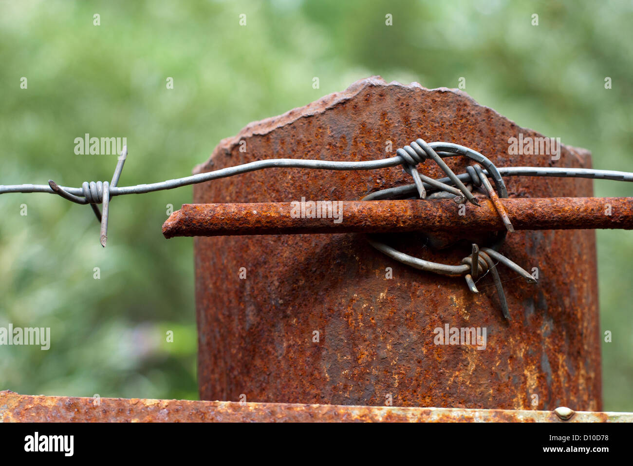 rusty column with barbed wire with focus set on it Stock Photo - Alamy