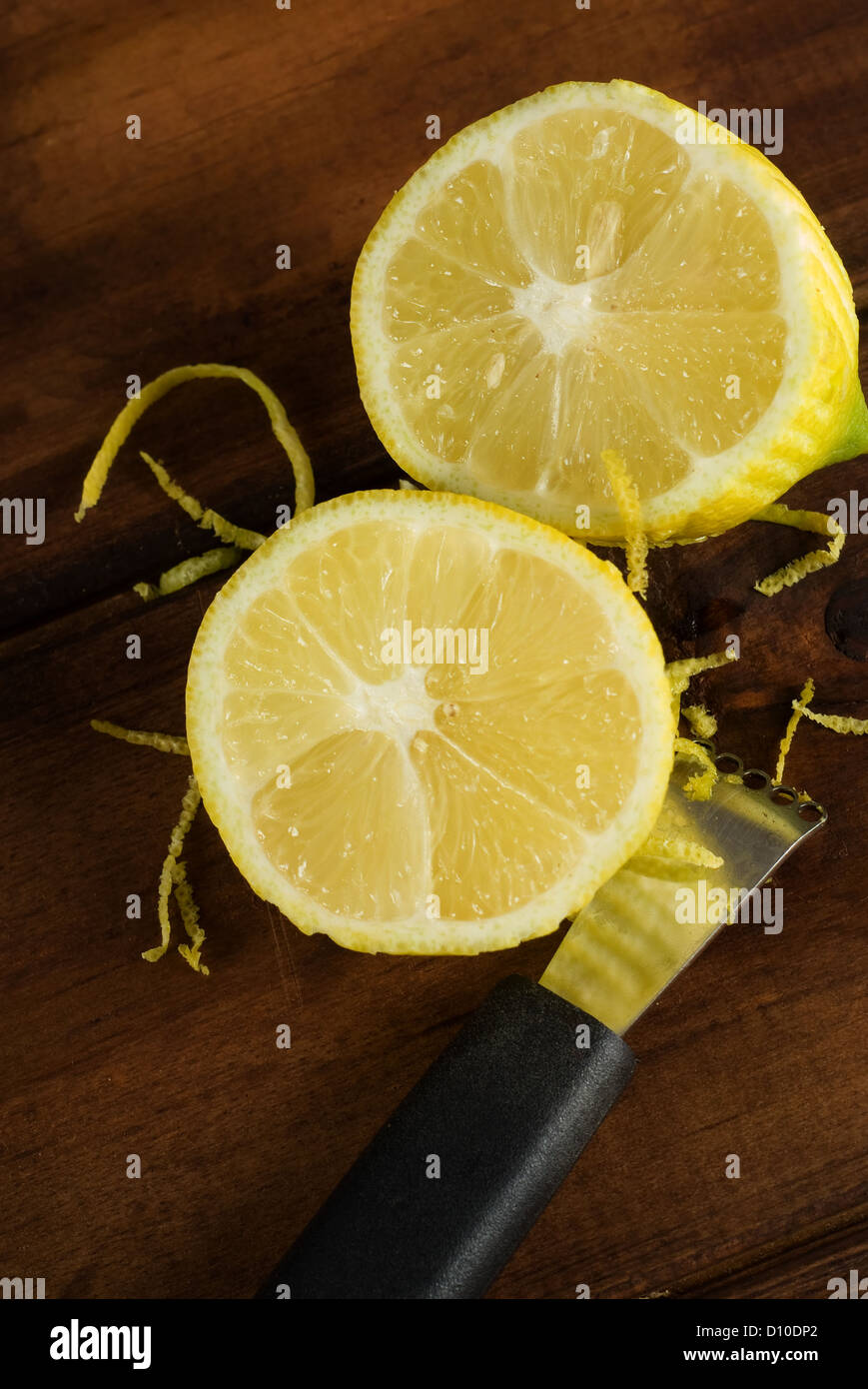 Zesting or sested lemon on wooden table with kitchen implement Stock ...