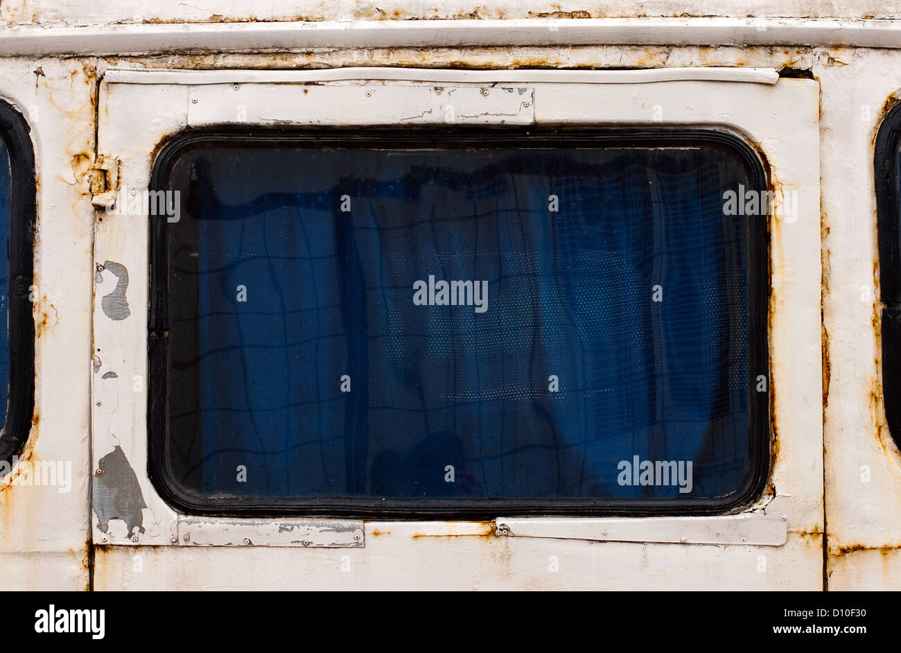 rusty window of an old bus with a bright blue curtain Stock Photo - Alamy