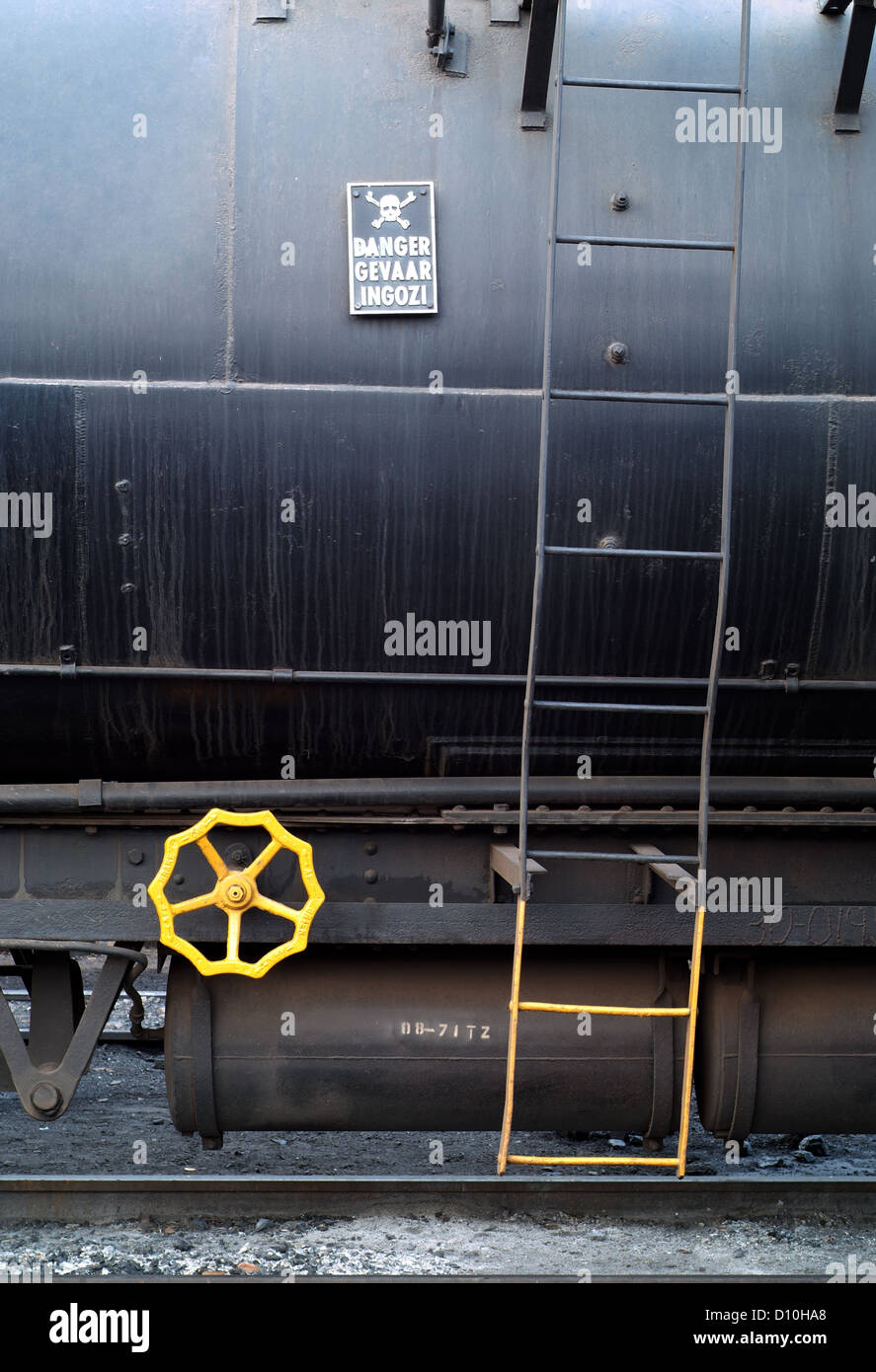 Danger sign and yellow brake wheel on side of toxic chemical railway ...