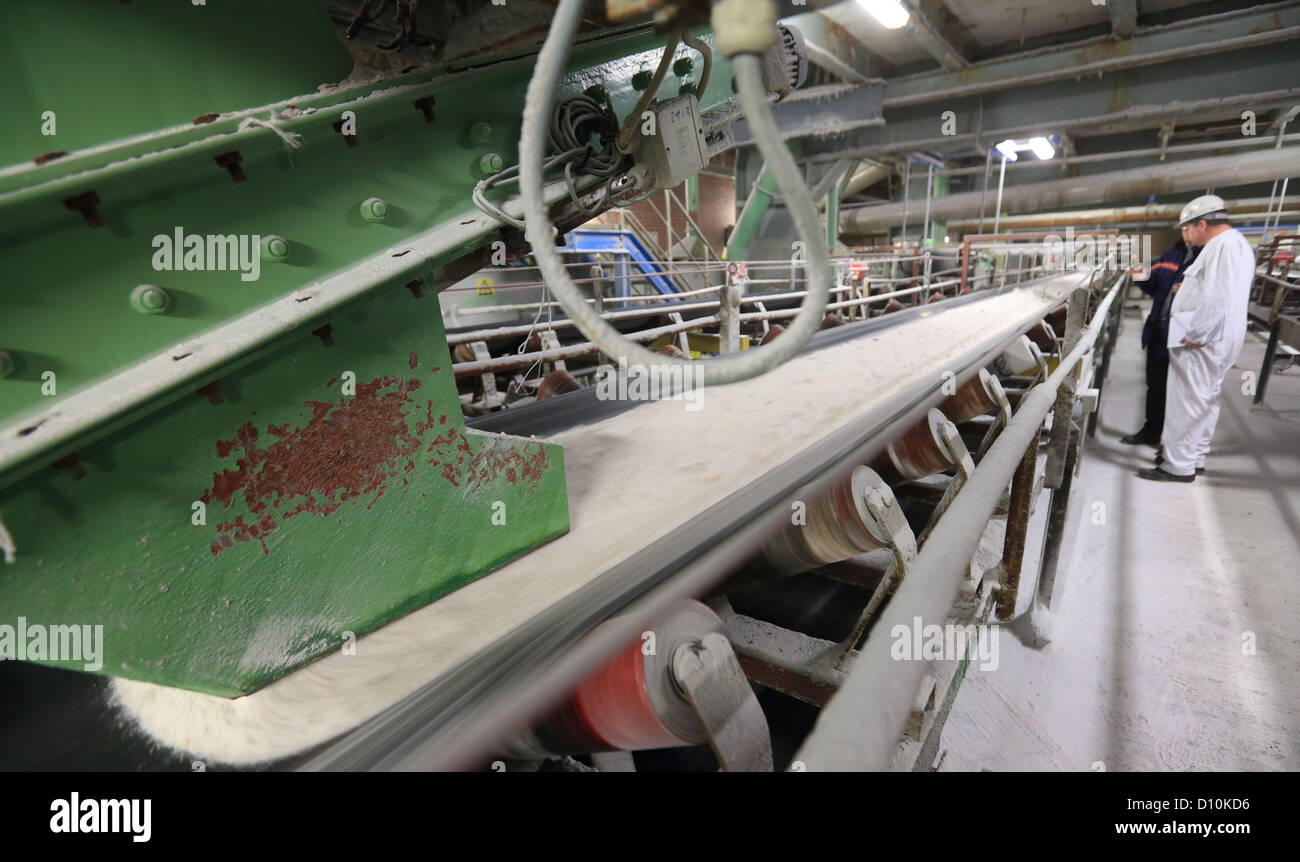 A miner observes the transportation of salt and potash on a conveyor ...
