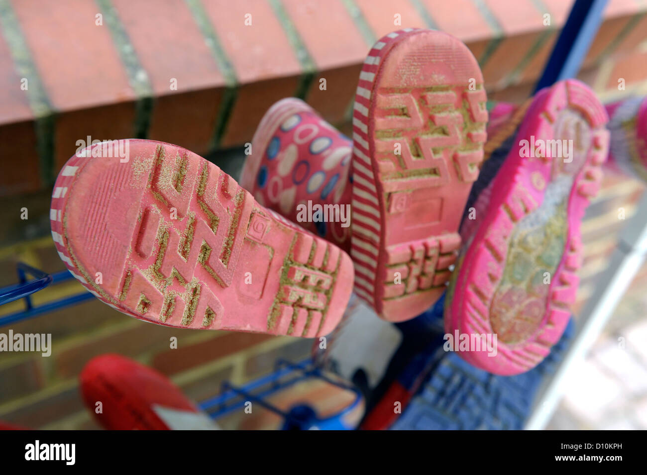 Coloured children's wellington boots on rack at a primary school Stock ...