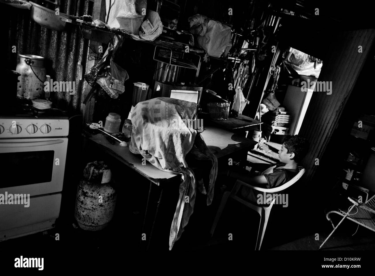 A young boy watches TV in a dark poor house located in the Mara ...