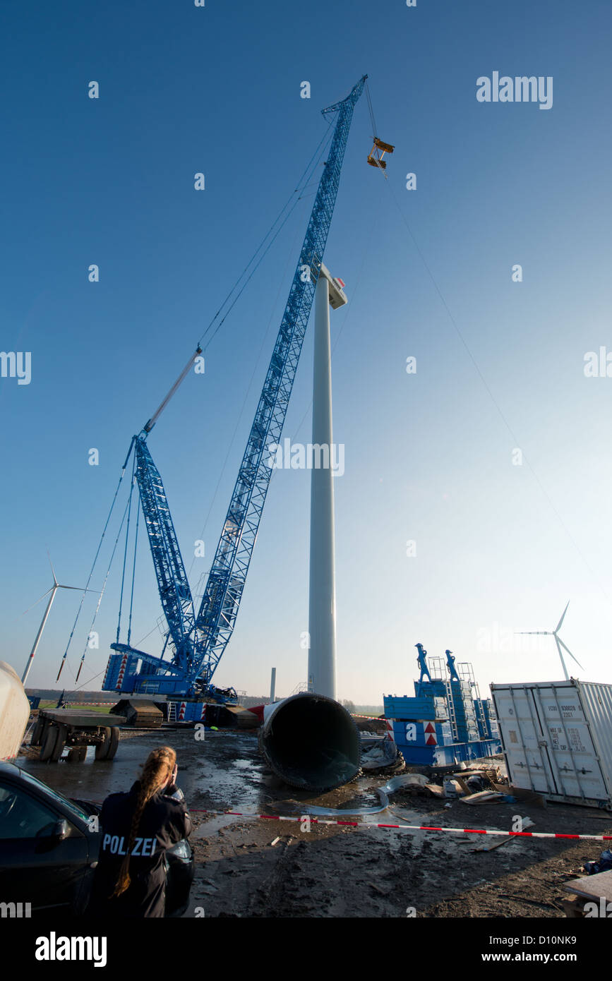 A police officer pictures a crushed crane cabin next to a fallen rotor ...