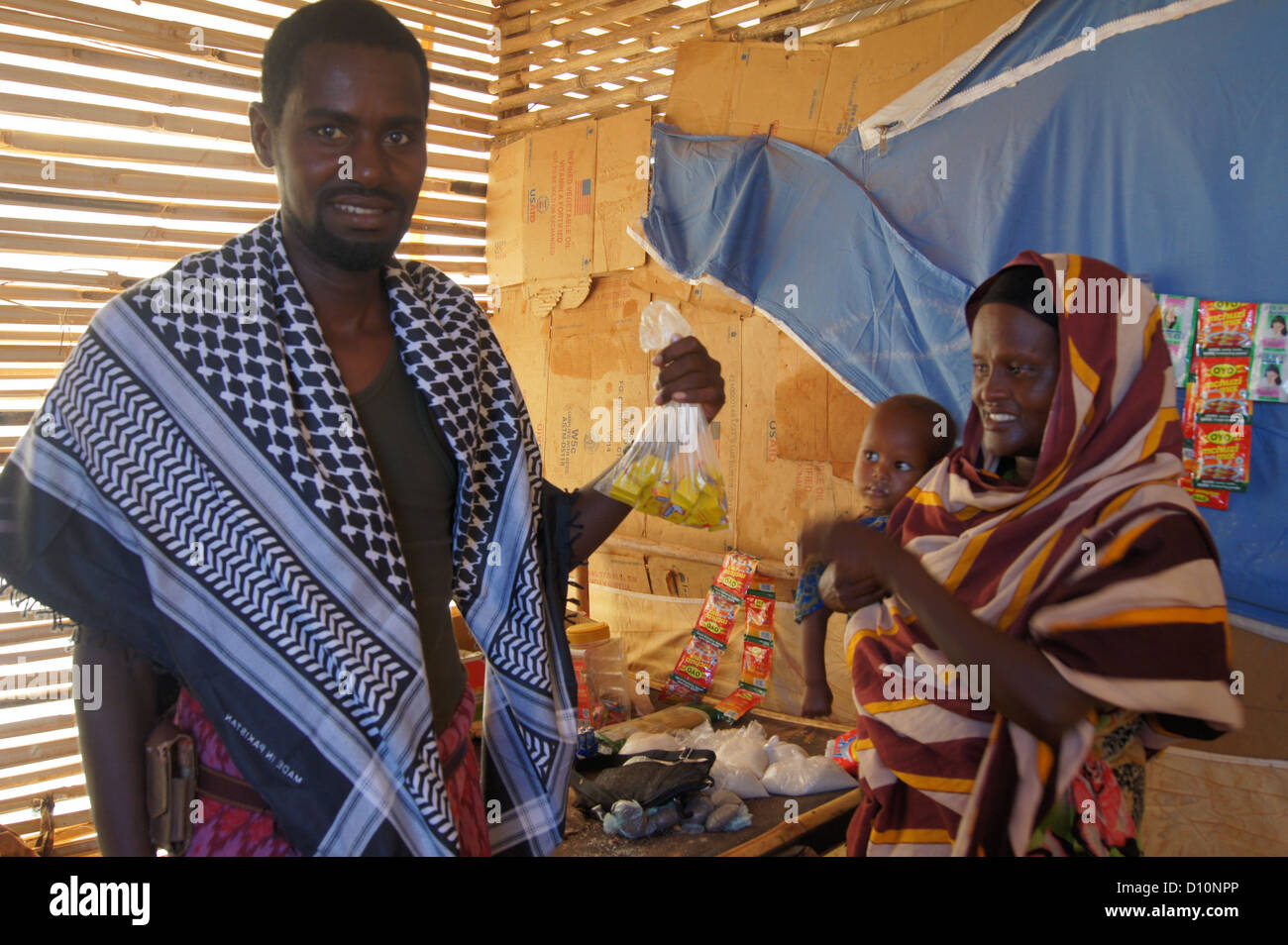 Members of a Somalian refugee family stand in their small retail market ...