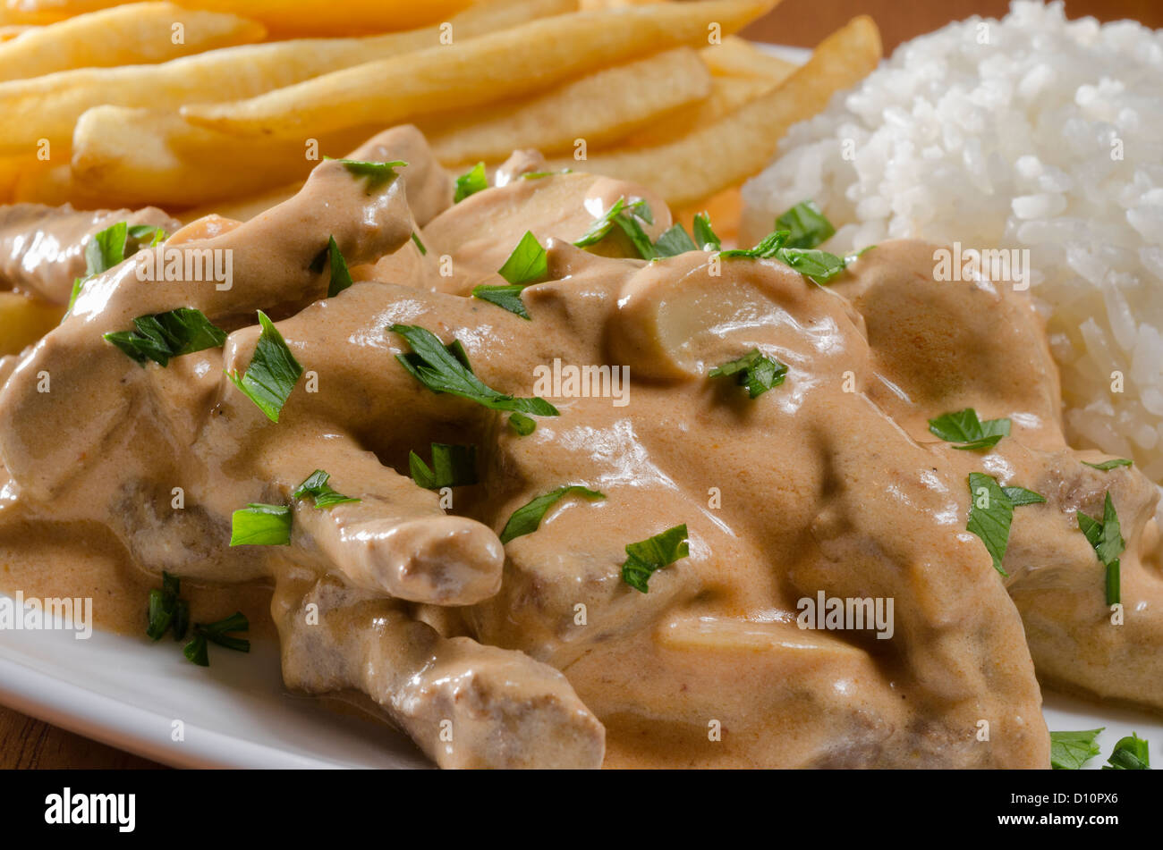 beef stroganoff with french fries and white rice, close-up Stock Photo ...
