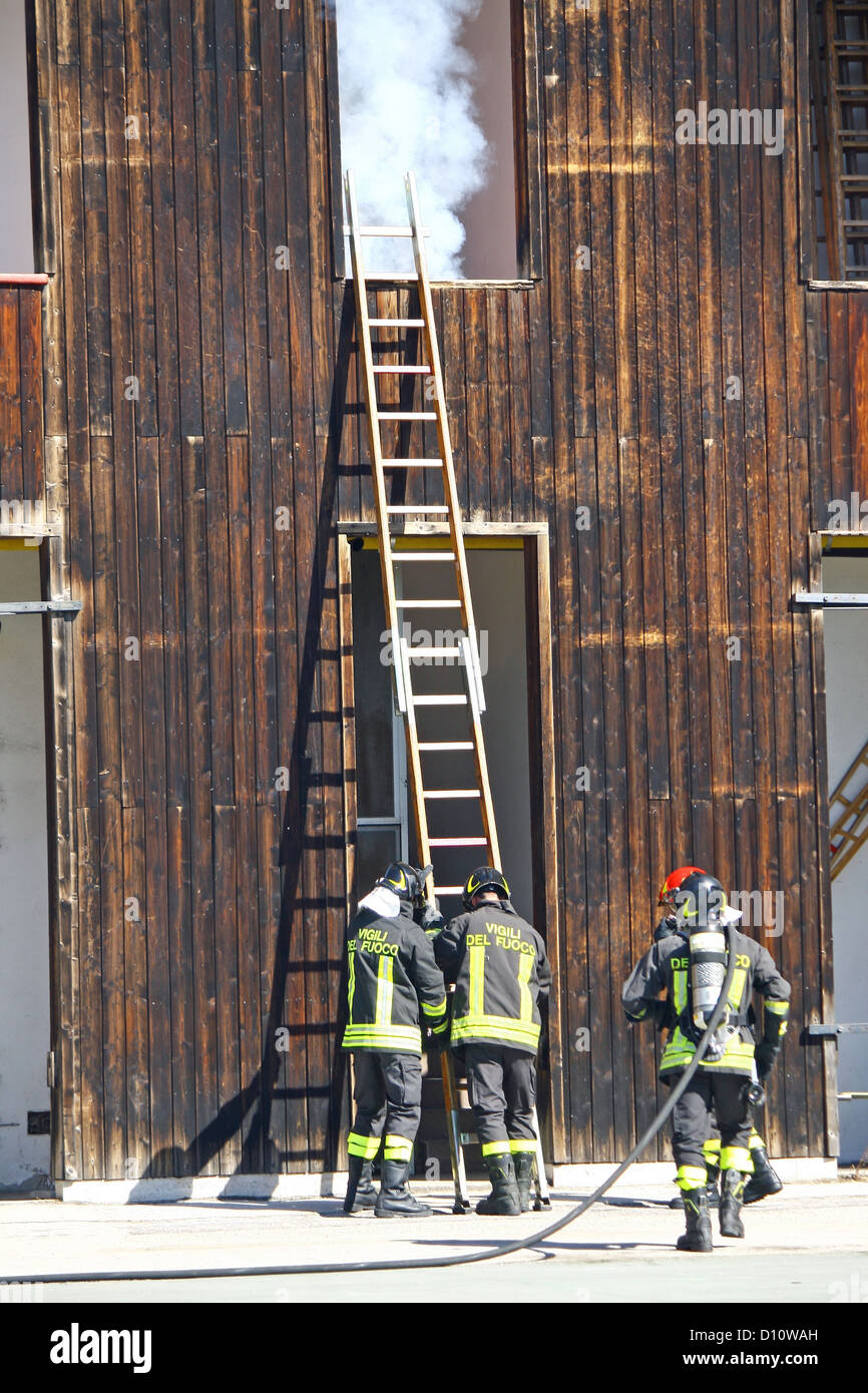 Firefighters extinguish a fire with white smoke in their fire station ...