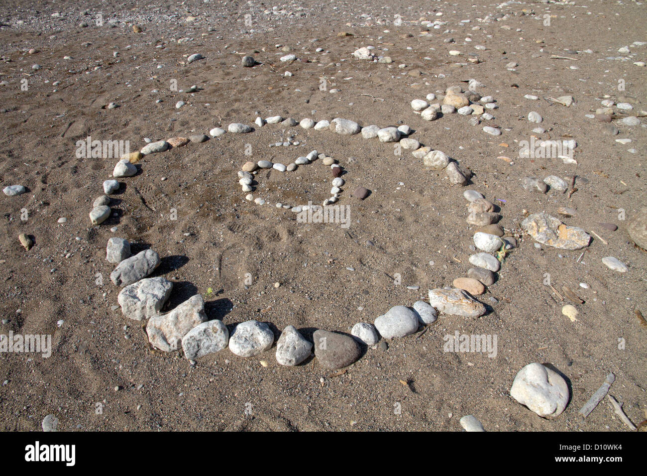 drawings artwork with stones on sand Stock Photo - Alamy