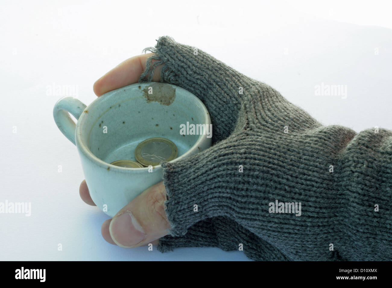 a poor hand holding a cup with route in the euro money Stock Photo - Alamy