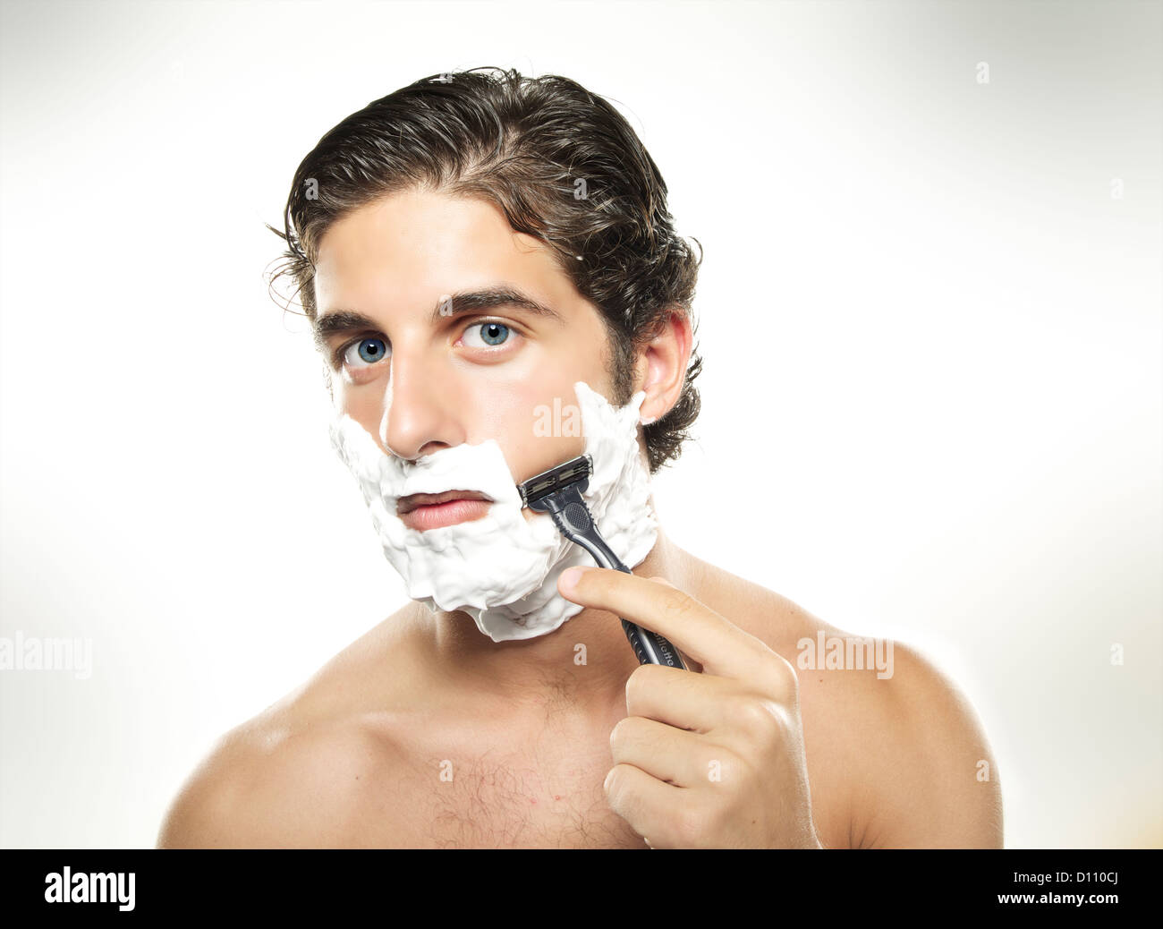 Young man shaving his face Stock Photo - Alamy