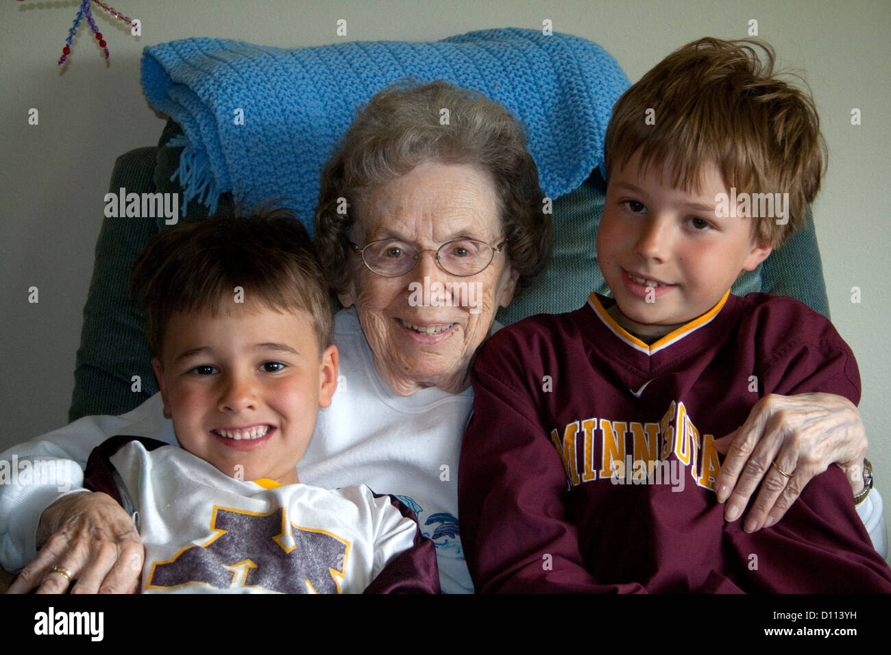 Happy Great grandmother age 95 holding her two great grandsons age 7 ...