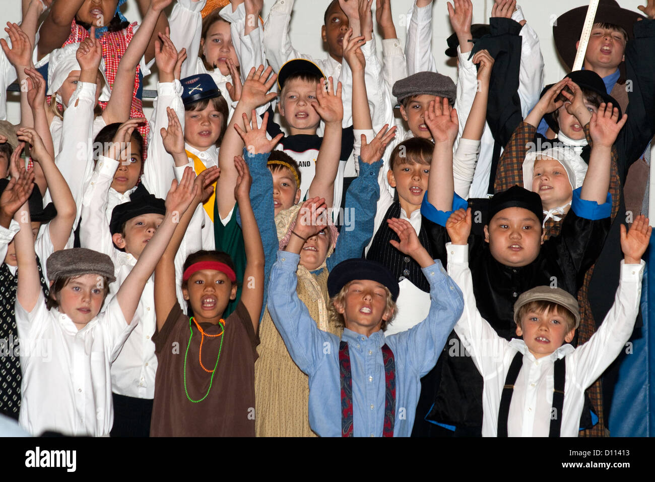 Exuberant school singers age 10 with arms over head in historic ...