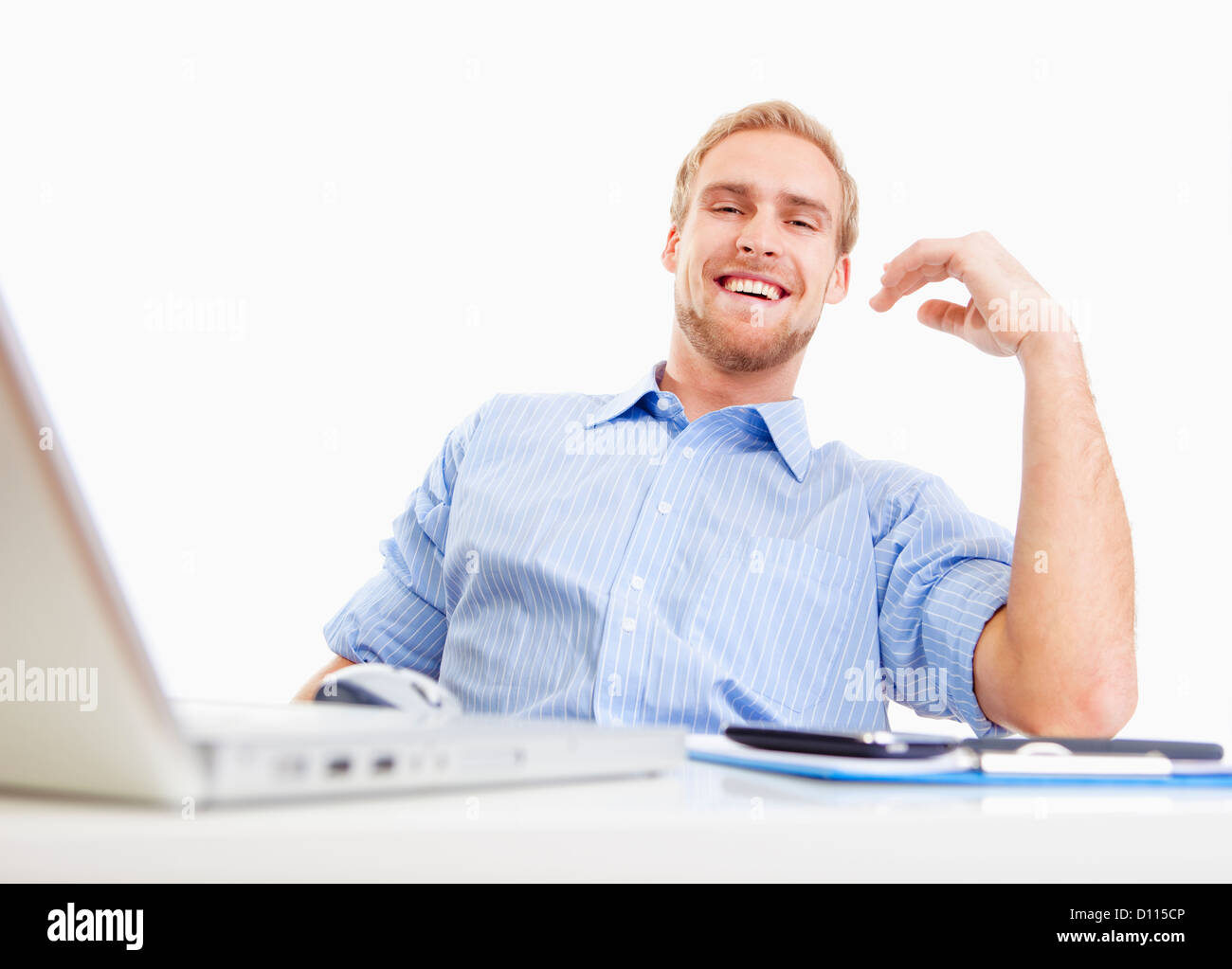 young man sitting behind desk at the office smiling Stock Photo - Alamy