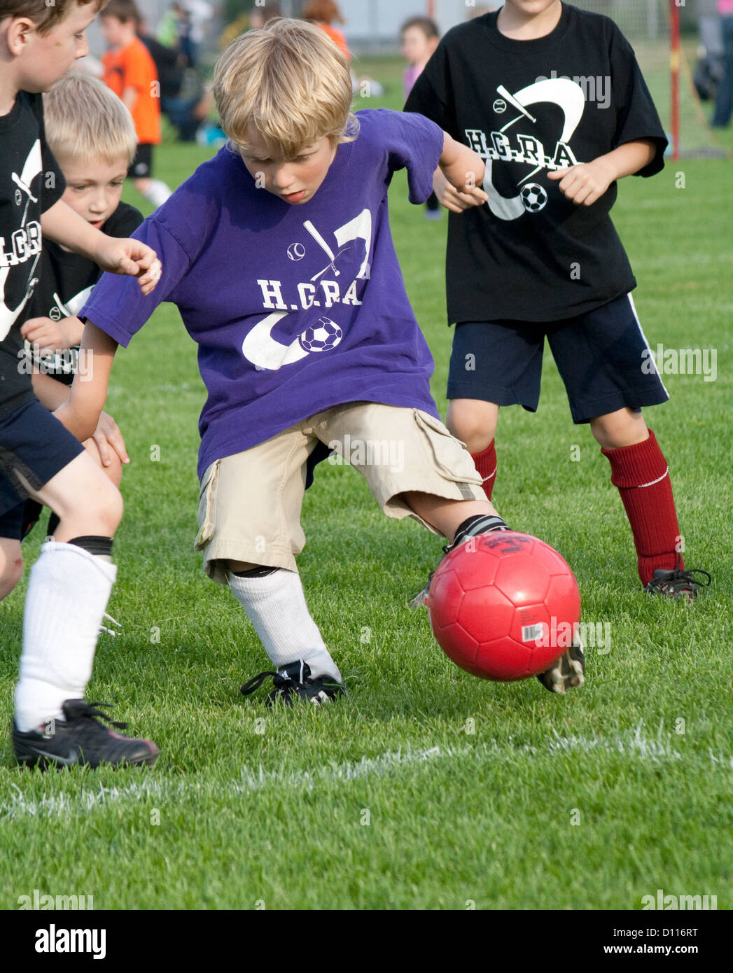 Boy age 7 kicking ball in very active soccer game. Carondelet Field by ...