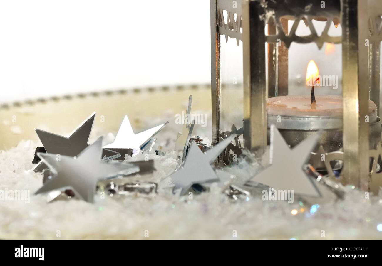 silver stars against a lit candle holder on a golden plate Stock Photo ...
