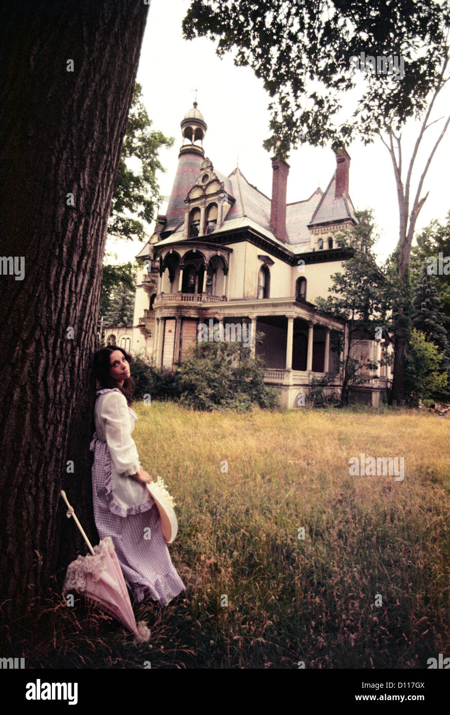 1960s 1970s WOMAN STANDING BESIDE TREE FRONT OF ABANDONED HAUNTED ...