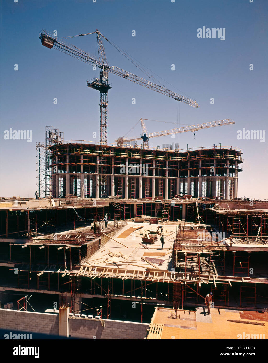 1970s 1980s OFFICE BUILDING CONSTRUCTION SITE WITH TWO CRANES Stock ...
