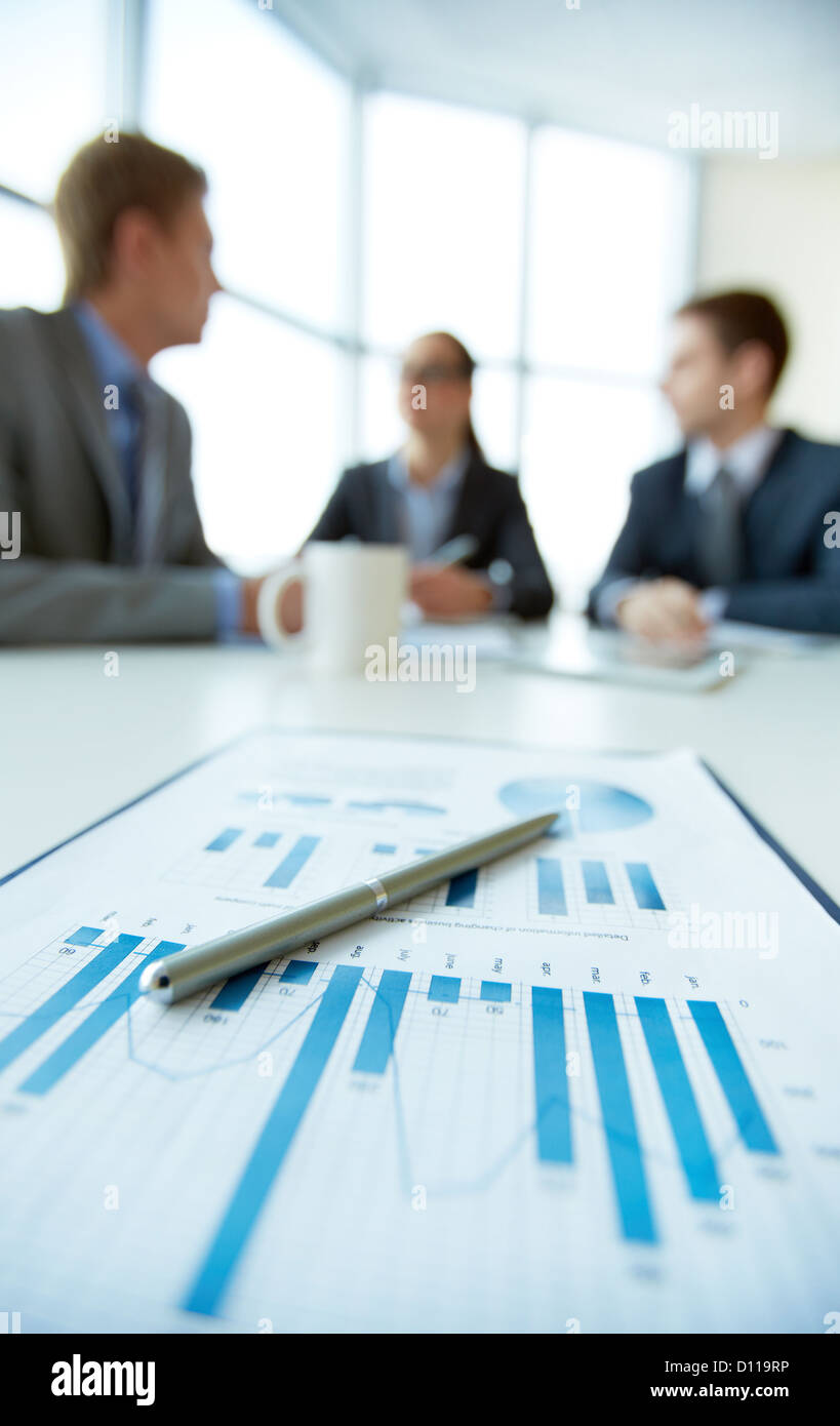 Business document on background of employees planning work at meeting ...