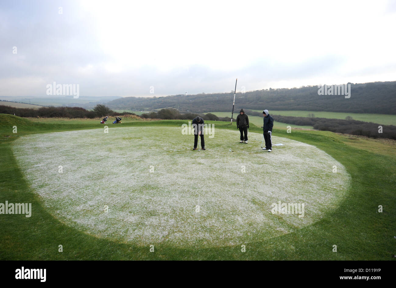 Three hardy golfers putting out on the first green at Waterhall Golf ...