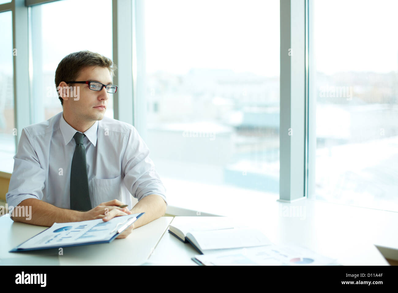 Image of smart businessman with document looking in the office window ...