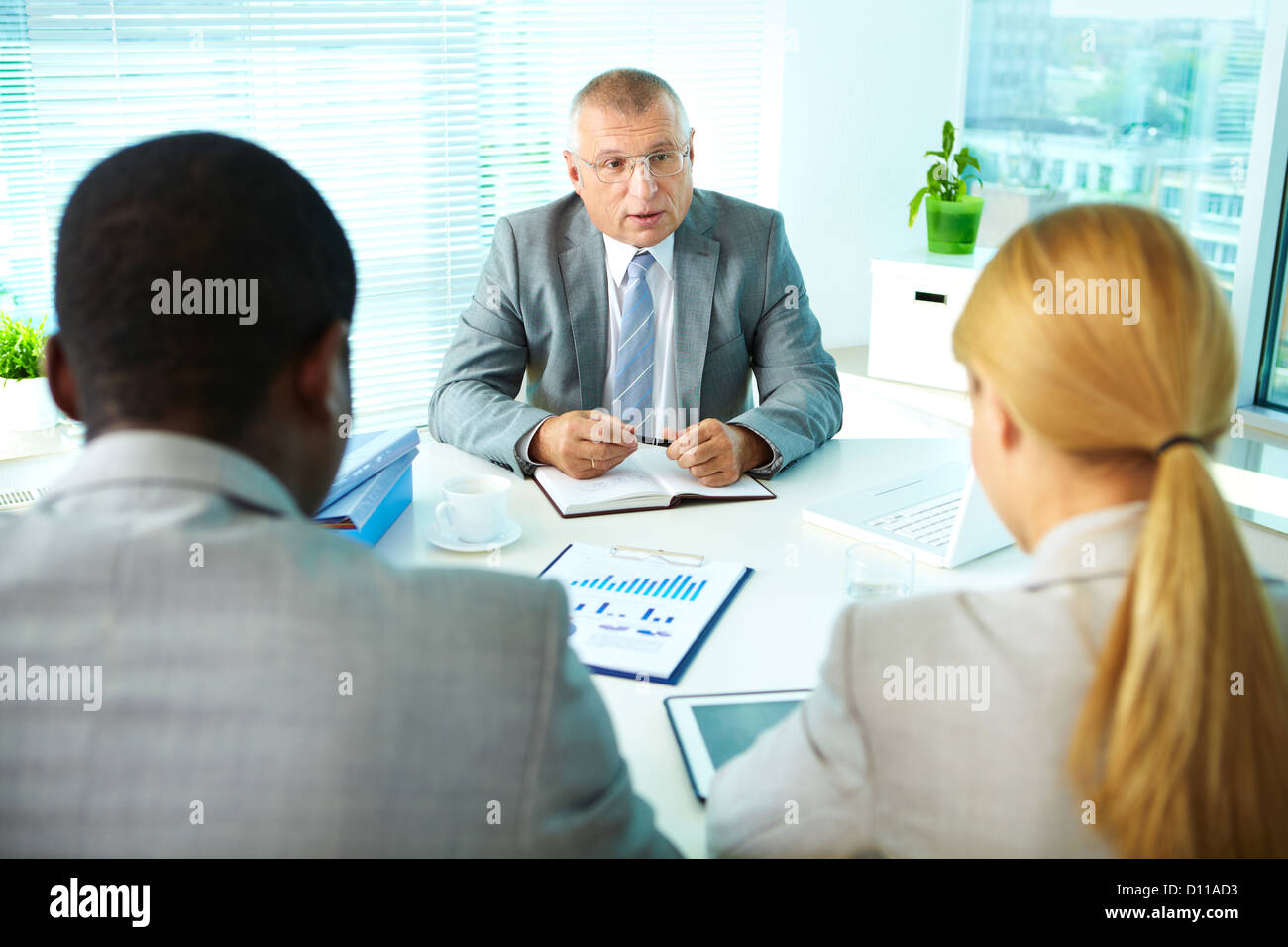 Portrait of serious boss interacting with his employees Stock Photo - Alamy