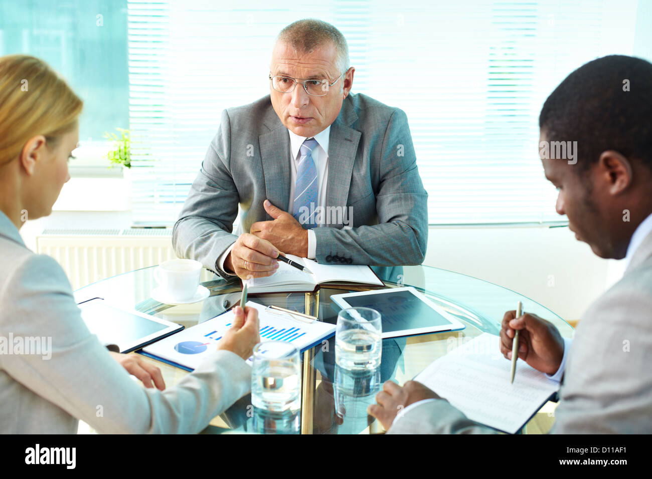 Portrait of serious boss interacting with his employees Stock Photo - Alamy