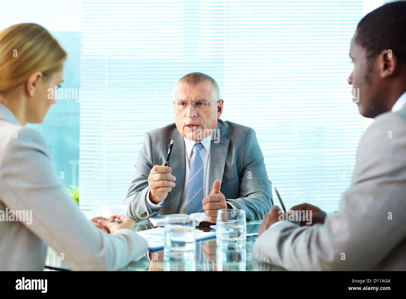 Portrait of serious boss talking to his employees Stock Photo - Alamy