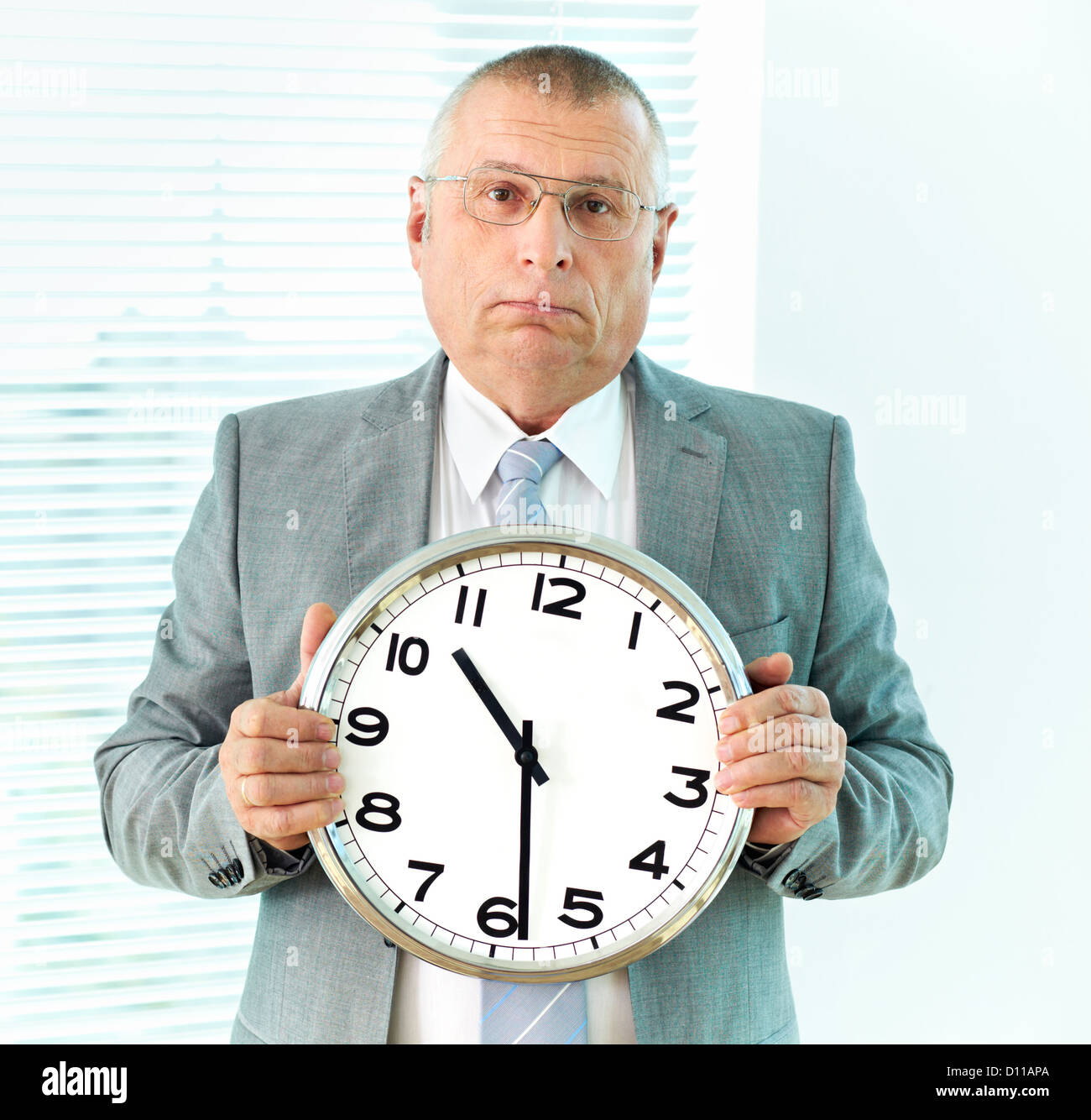 Portrait of elderly businessman with clock looking at camera Stock ...