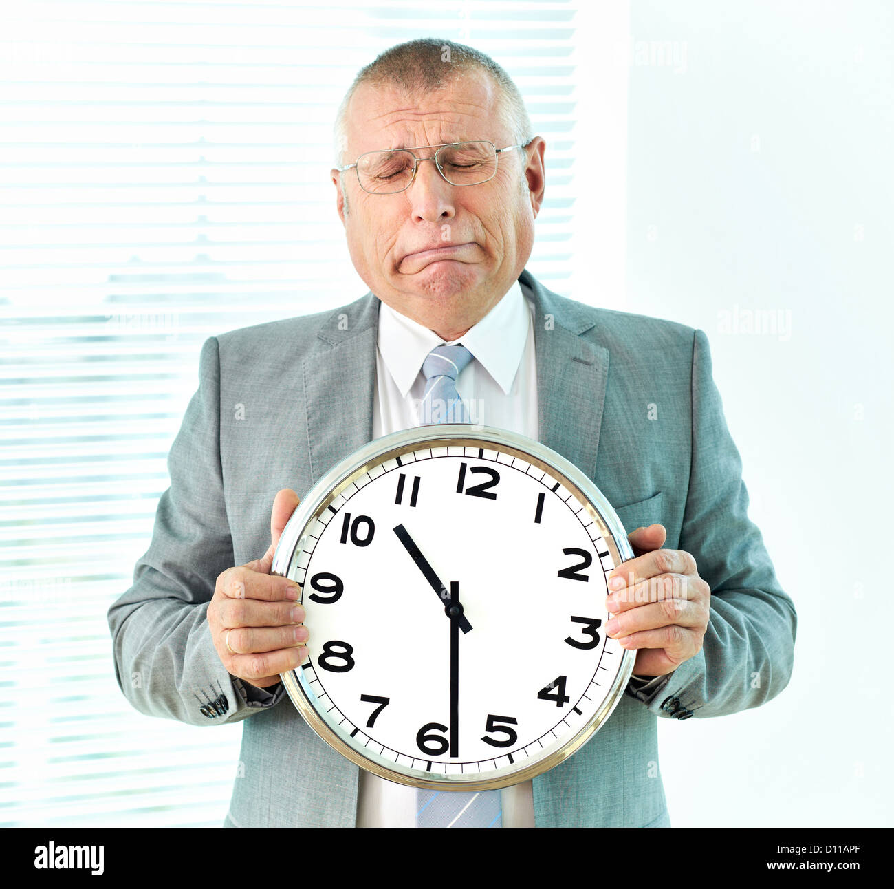 Portrait of elderly businessman with clock expressing unability Stock ...