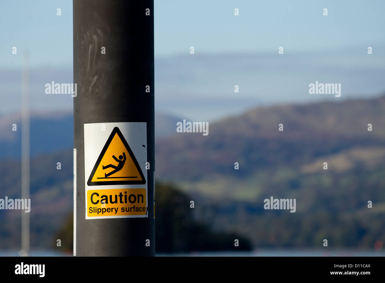 caution slippery surface sign on jetty on Lake Windermere Stock Photo ...