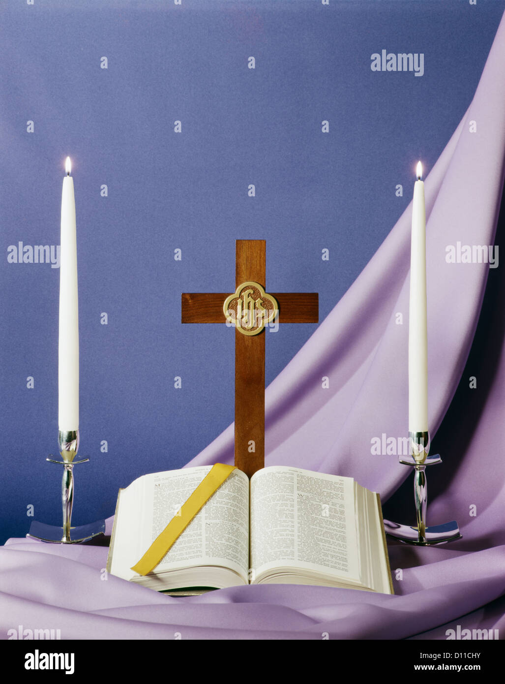 BIBLE OPEN TO BOOK OF ISAIAH CROSS AND CANDLES ON PURPLE BACKGROUND ...